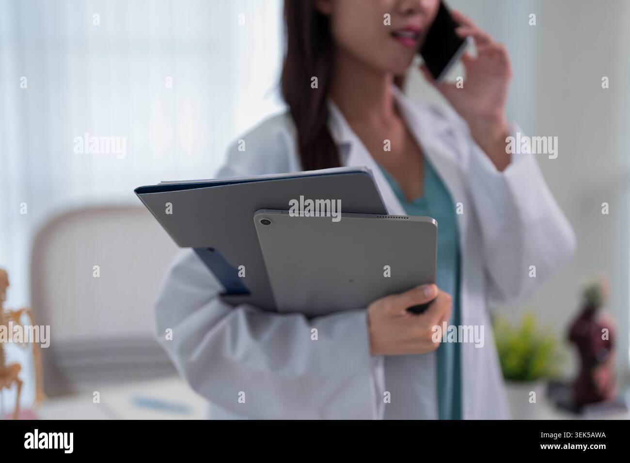 Asian women doctor holding tablet talking phone at modern hospital ...