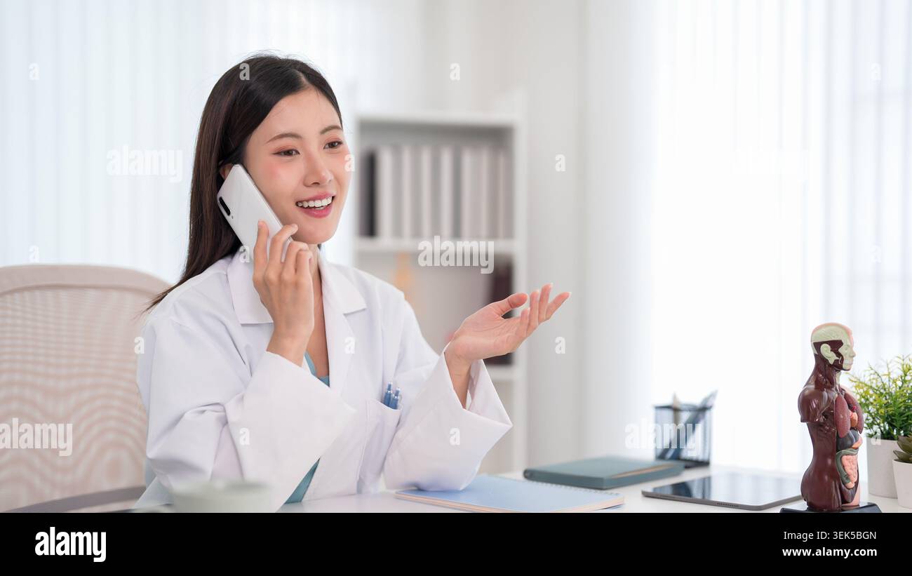 Asian doctor woman talking phone call explaining medical advice patient ...