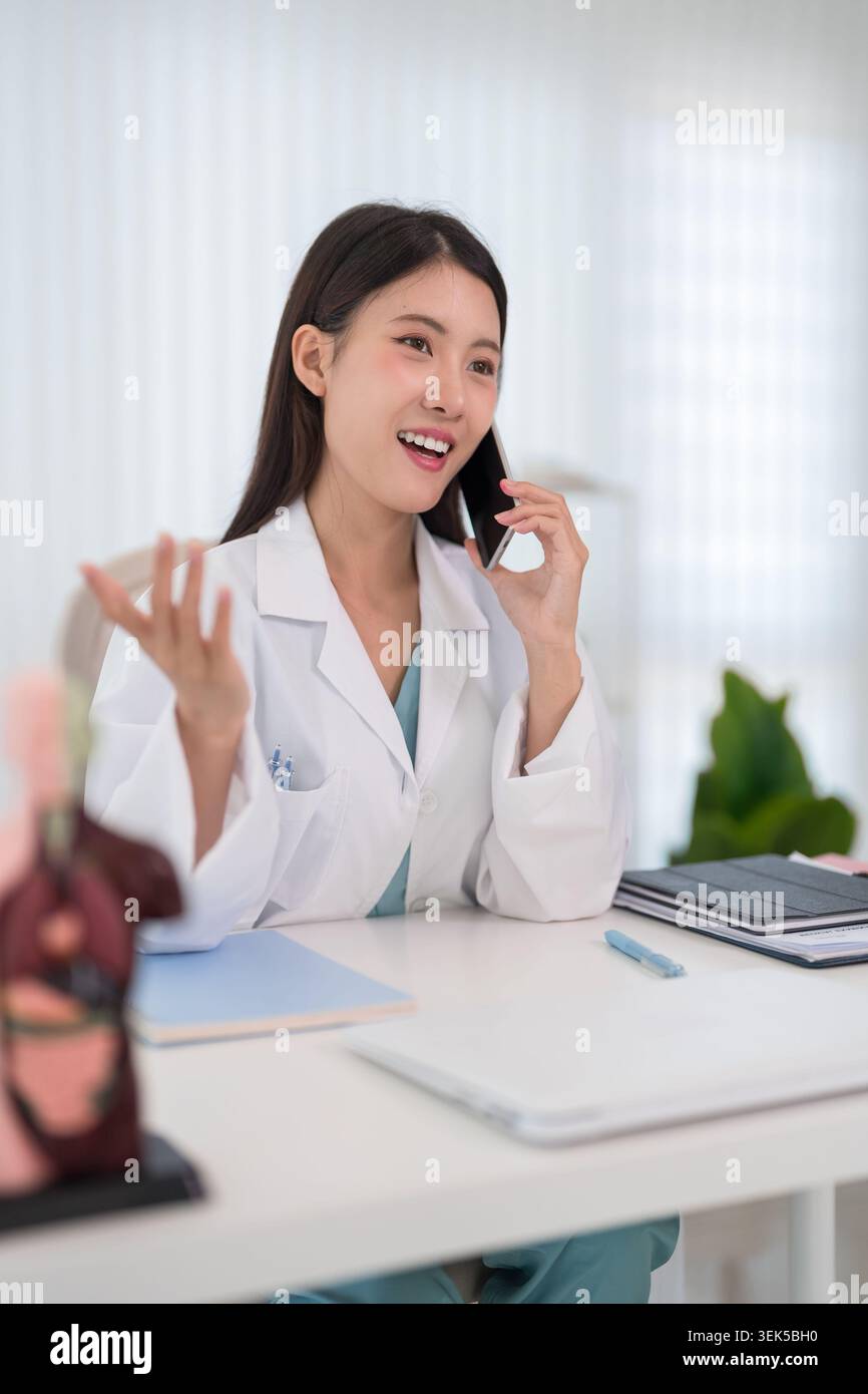 Asian female doctor consulting patient through phone call providing ...