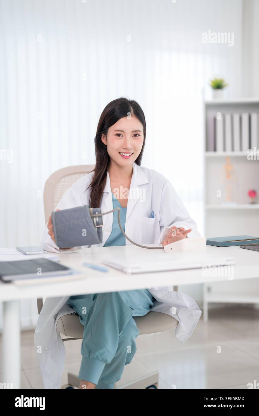 asian female doctor presenting tablet computer screen while seated at ...