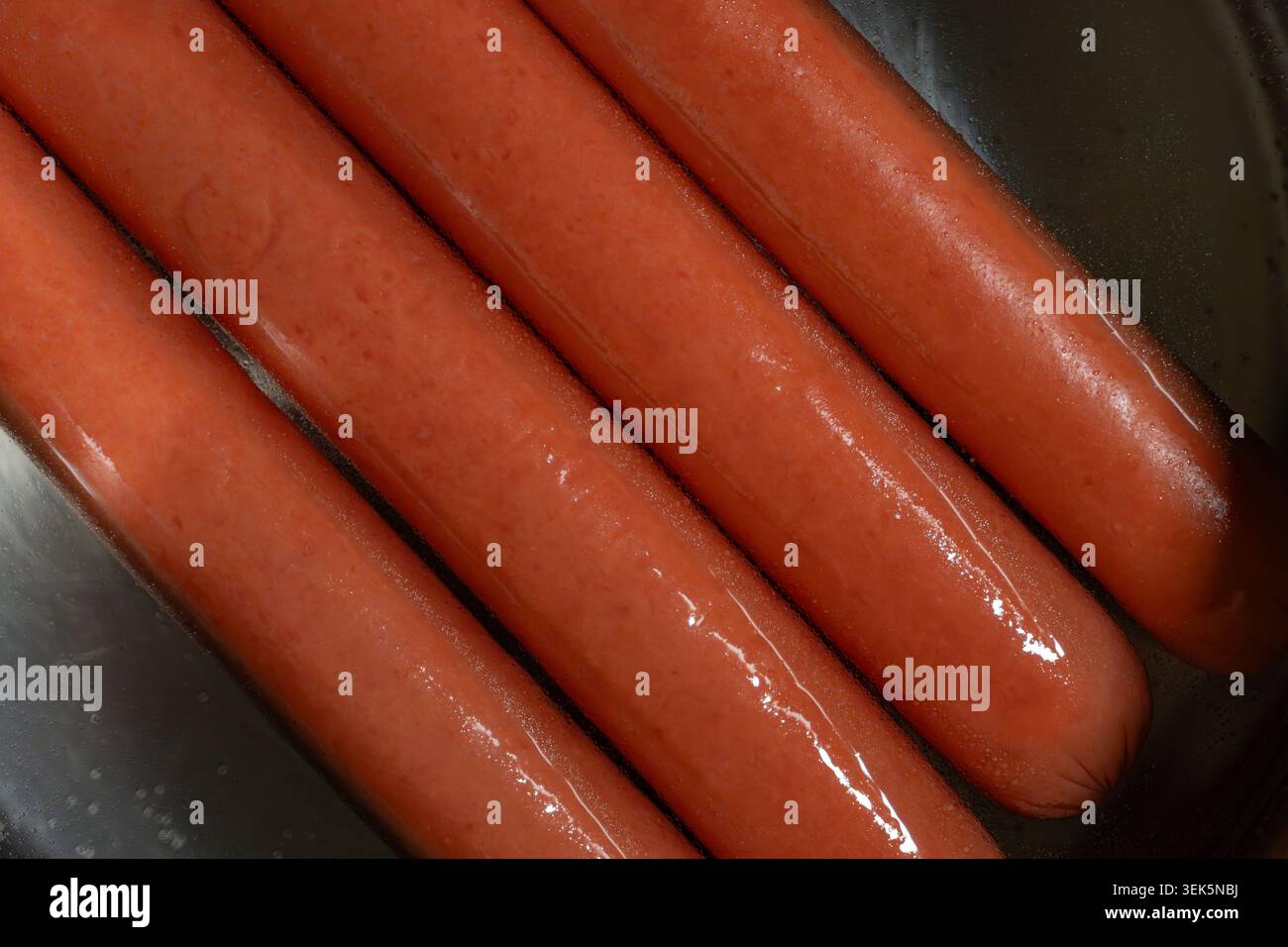 A top down macro shot captures a group of hot dogs in water Stock Photo ...