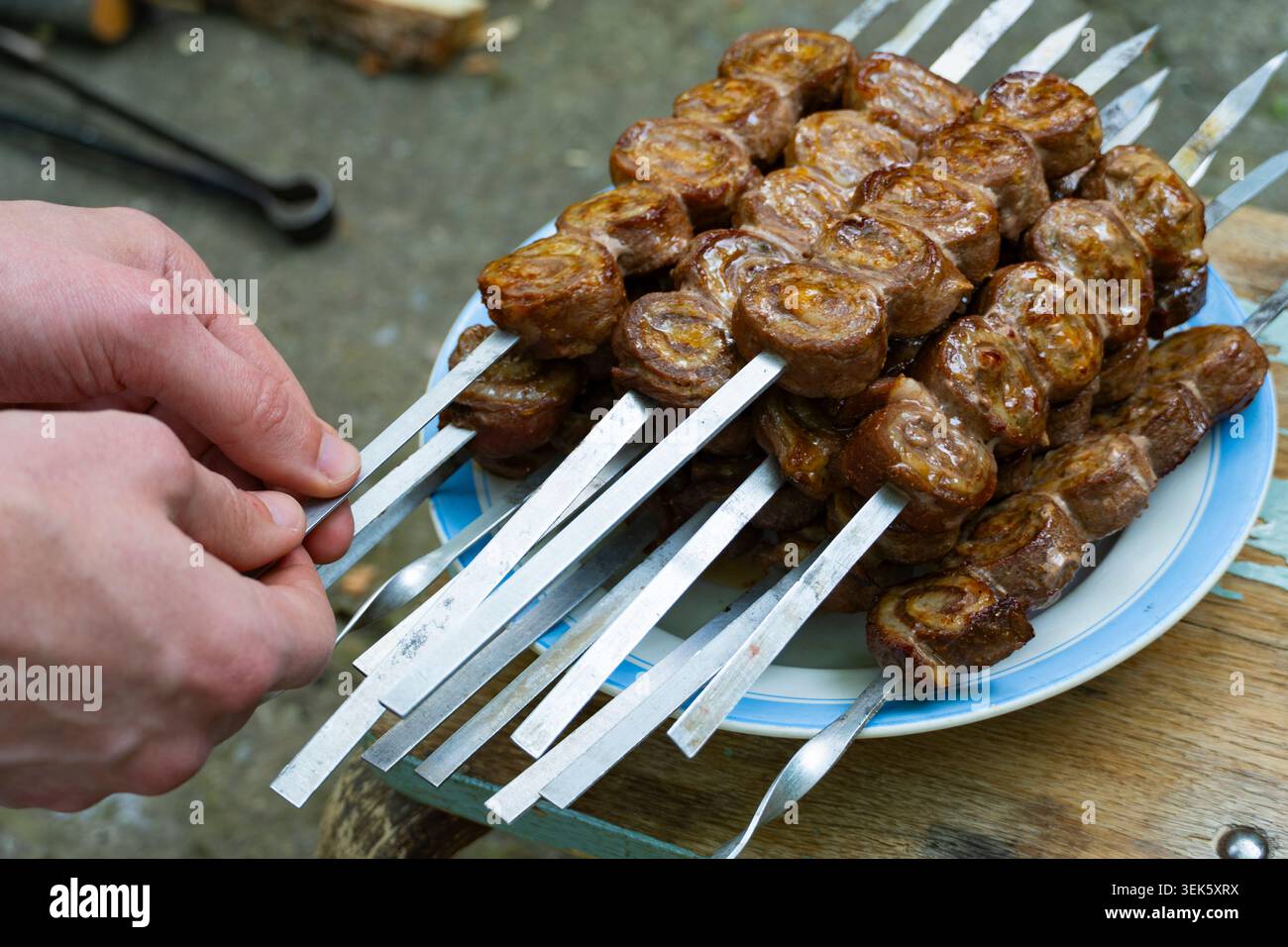 Close-up of grilled rolled meat skewers with golden-brown surface ...