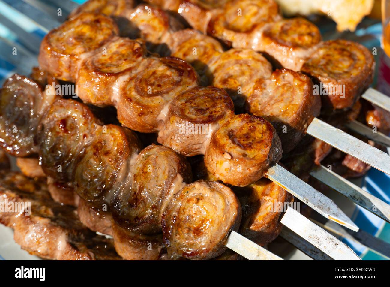 Close-up of grilled rolled meat skewers with golden-brown surface ...