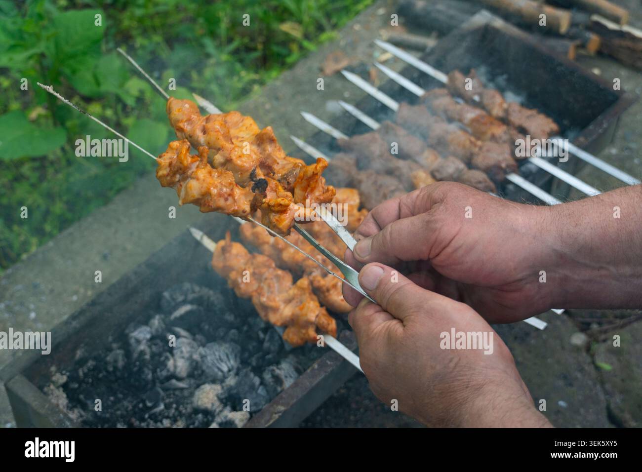 Close-up of marinated meat skewers grilling over hot charcoal, with ...
