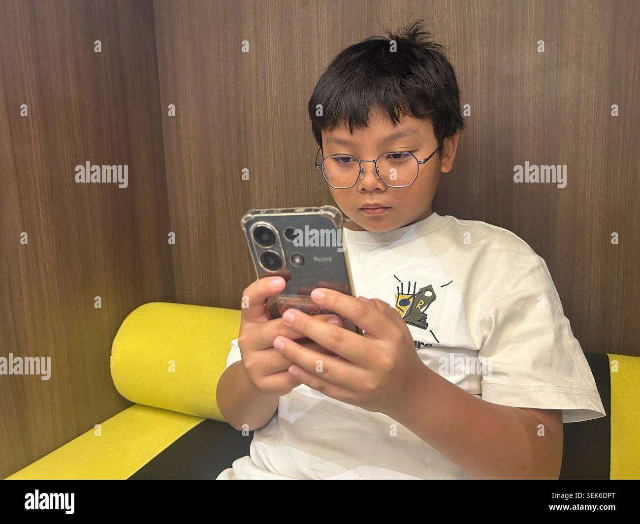 Hew Chee Weng, 11, uses a smartphone in Kuala Lumpur, Malaysia, Monday ...