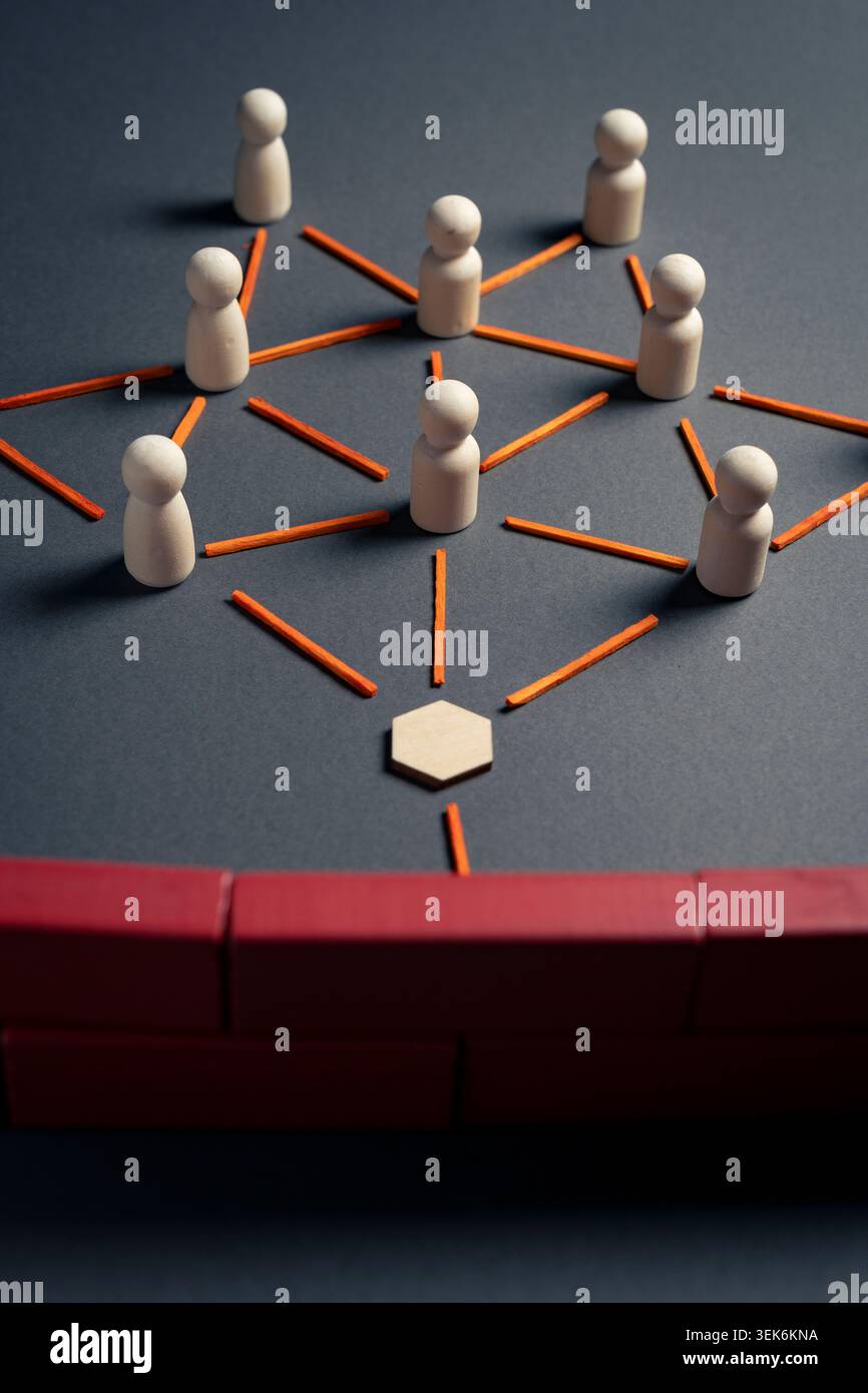 A vertical high angle shot of wooden pawns in a web network blocked by ...