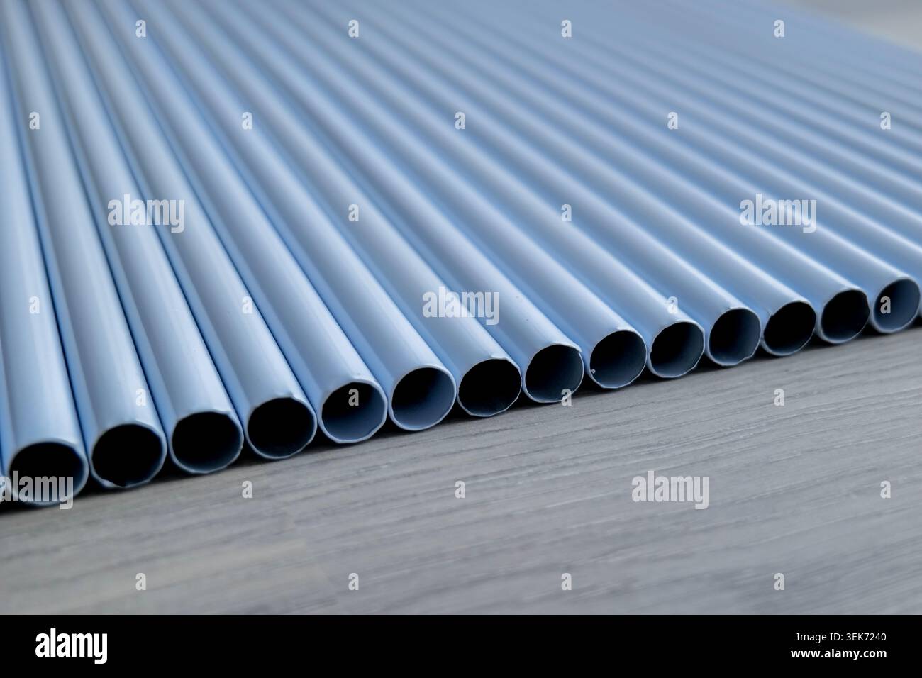 Row of light blue PVC pipes on concrete surface Stock Photo - Alamy