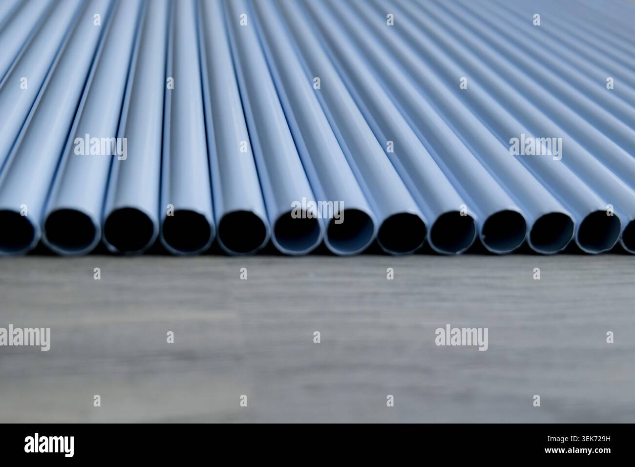 Row of light blue PVC pipes on concrete surface Stock Photo - Alamy