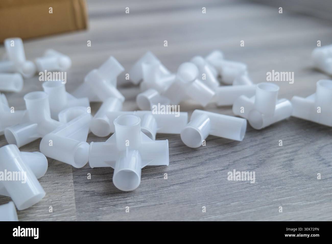 White Plastic Pipe Connectors Scattered on Wooden Floor for DIY ...