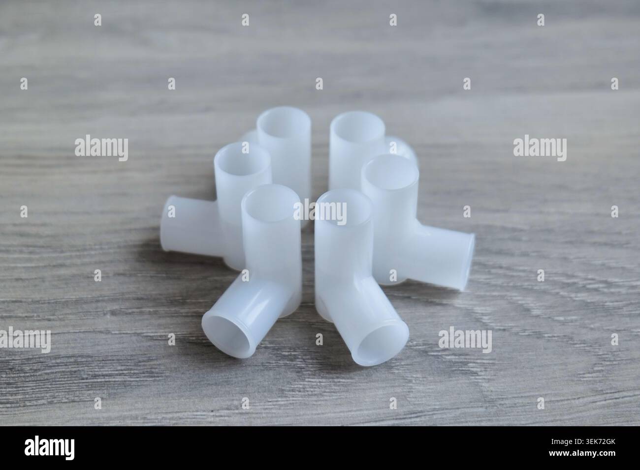 White Plastic Pipe Connectors on Wooden Background Stock Photo - Alamy