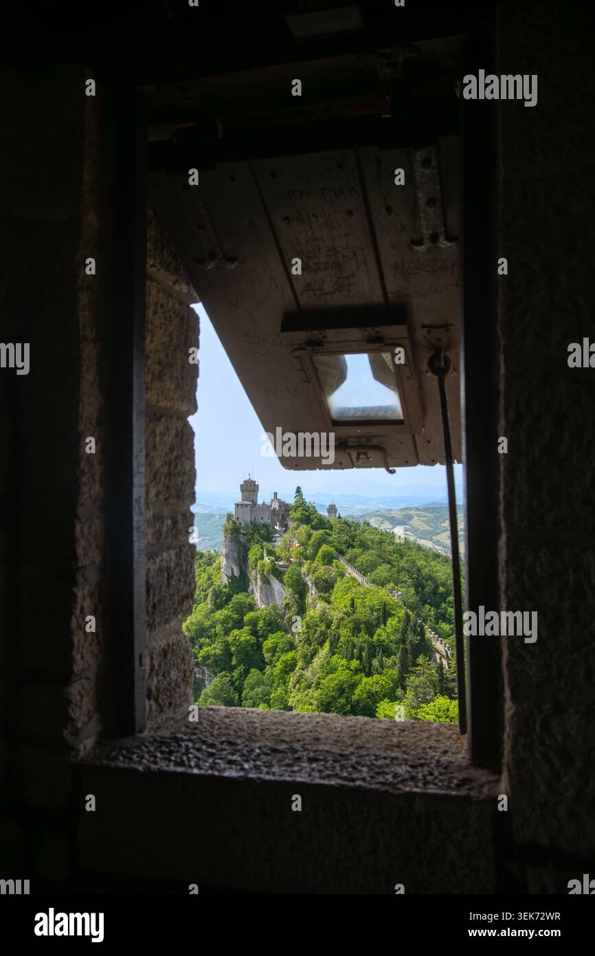 View from a dark stone window reveals a distant ancient fortress ...