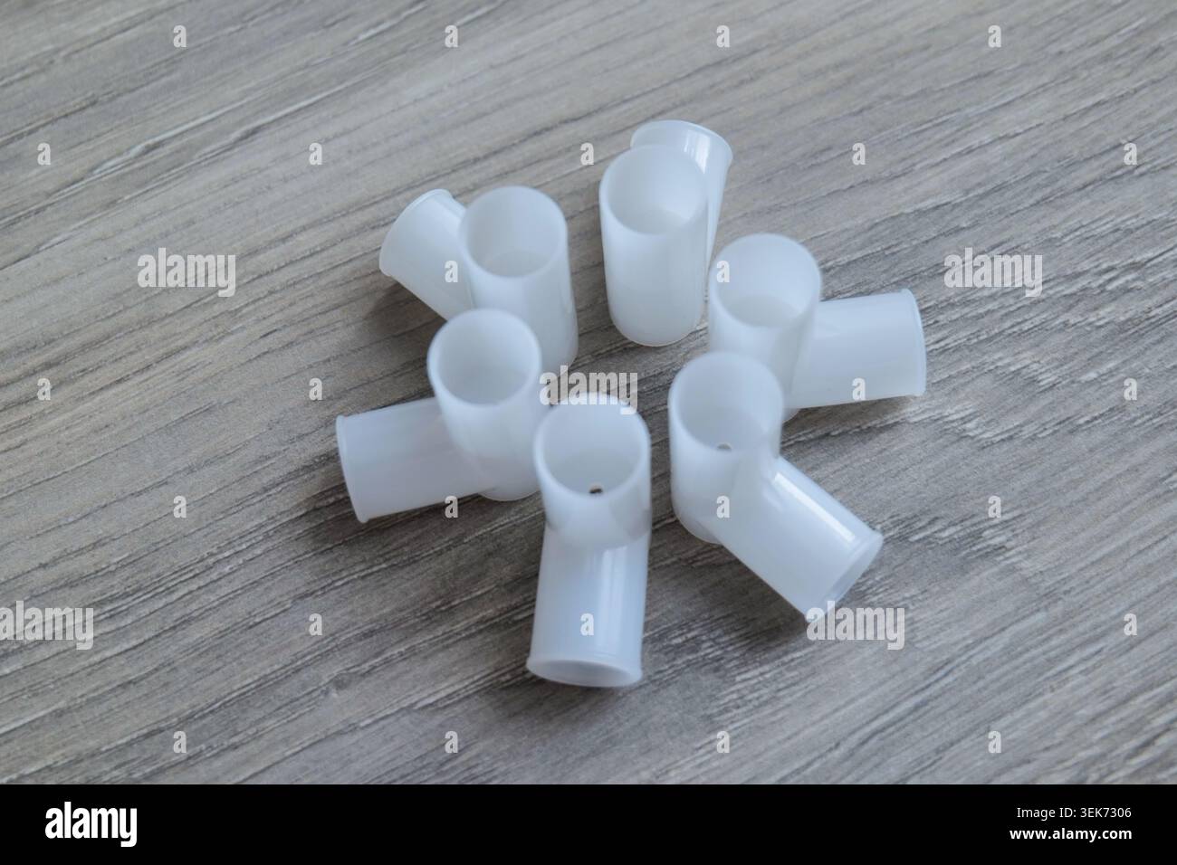 White plastic connectors arranged in circle on wooden surface Stock ...