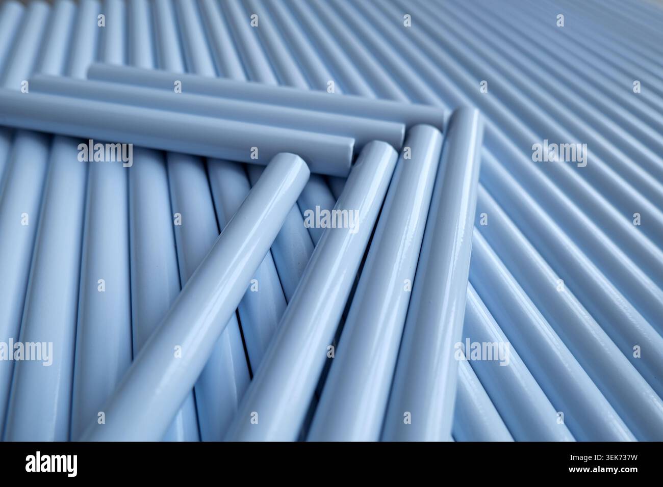 Hand holding white plastic pipes against a background of more pipes ...