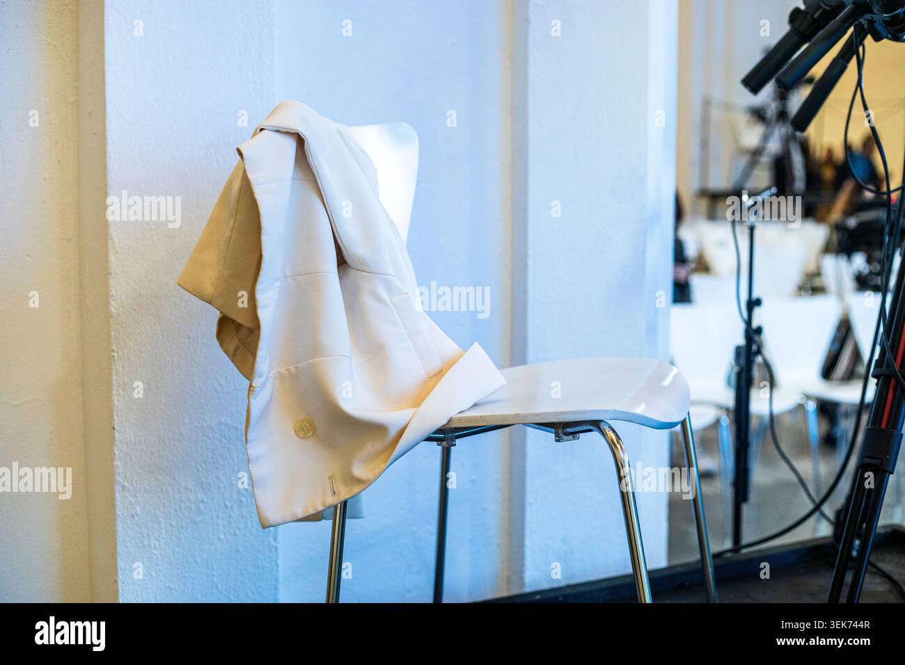 A white sweater hanging over the back of a white chair in the interior ...