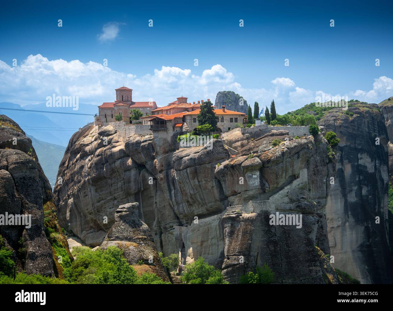 Ancient stone monastery buildings with orange roofs sit precariously on ...
