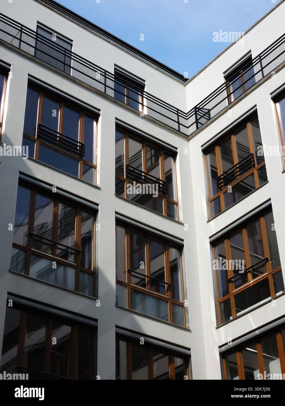 Modern apartment building facade with white walls, large windows and ...