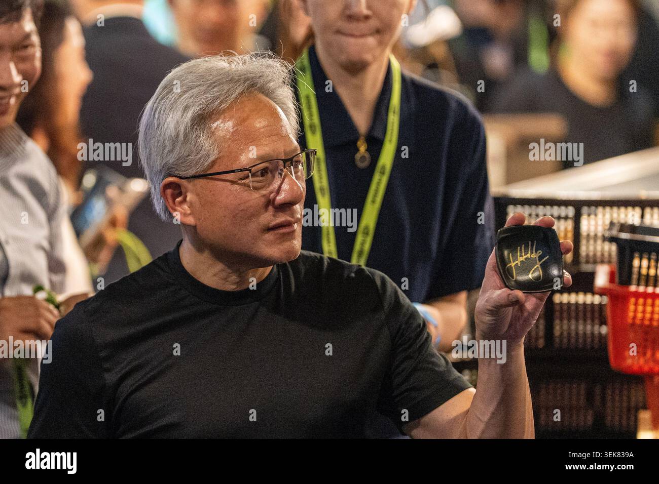 Jensen Huang, President and CEO of NVIDIA holding up a sign plate at a ...