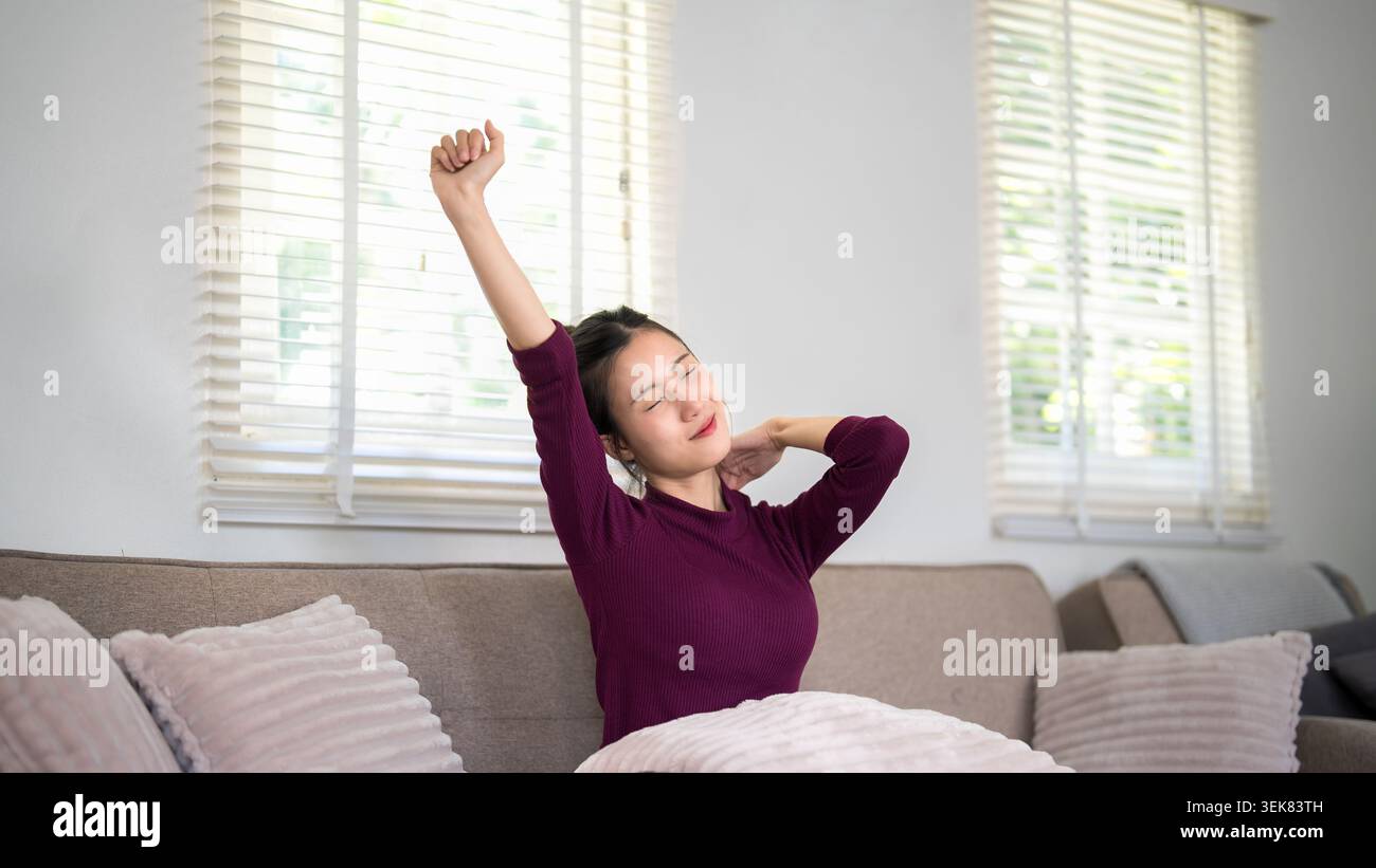 Asian women stretch arm wake up morning routine living room home bright ...