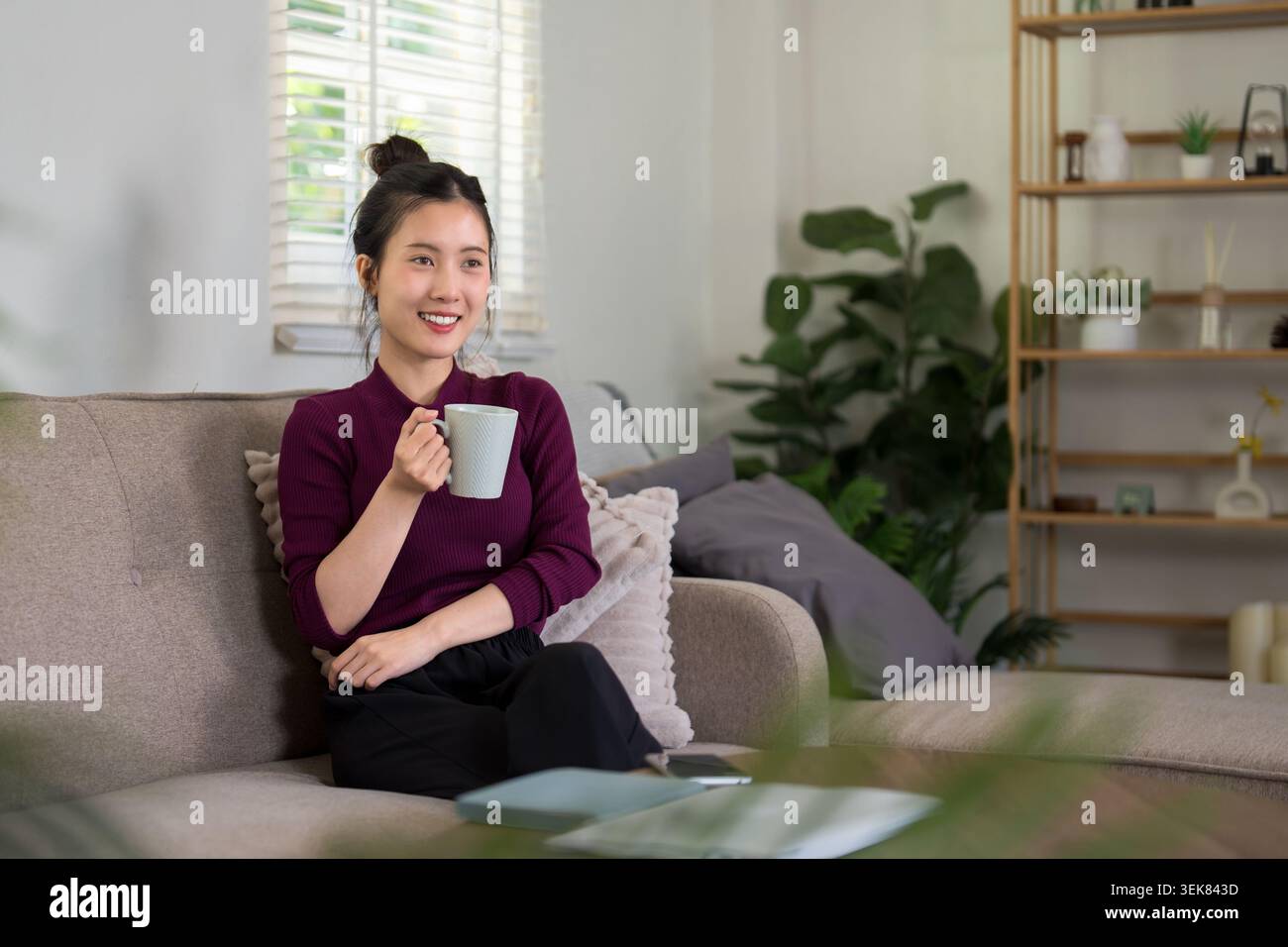 young Asian women relax at home living room sofa holding coffee mug ...