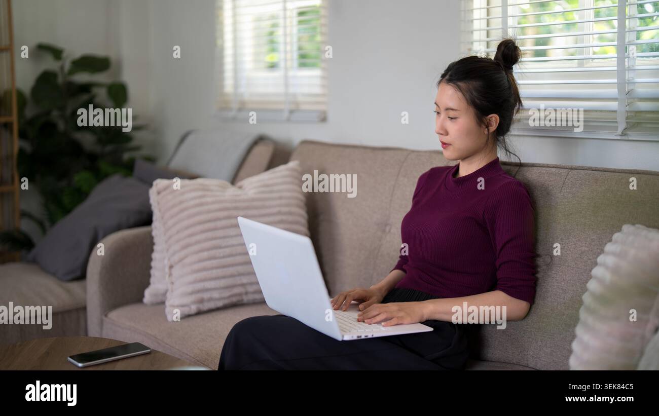 Asian woman professional using laptop computer sitting on sofa working ...