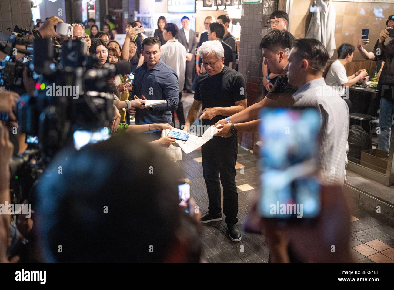 Jensen Huang, President and CEO of NVIDIA signing objects from fans ...