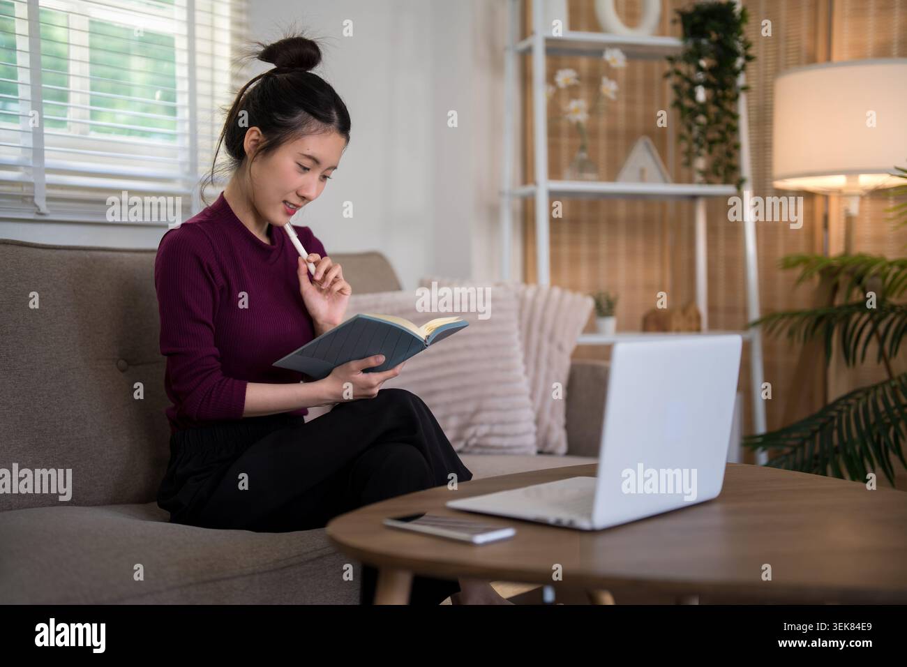 Asian woman studying medical textbook with laptop computer in ...
