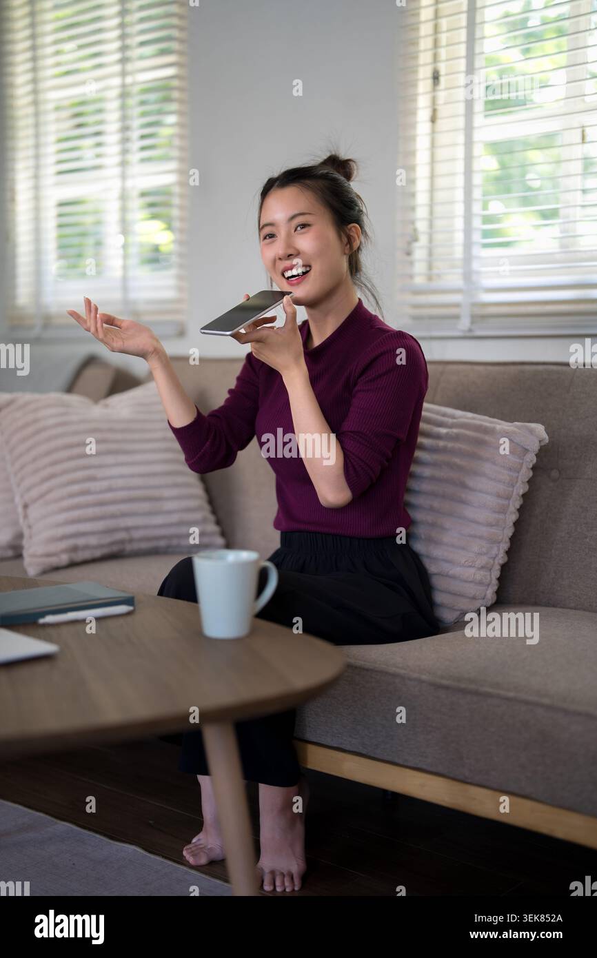 Asian young woman using smartphone voice assistant making hands free ...