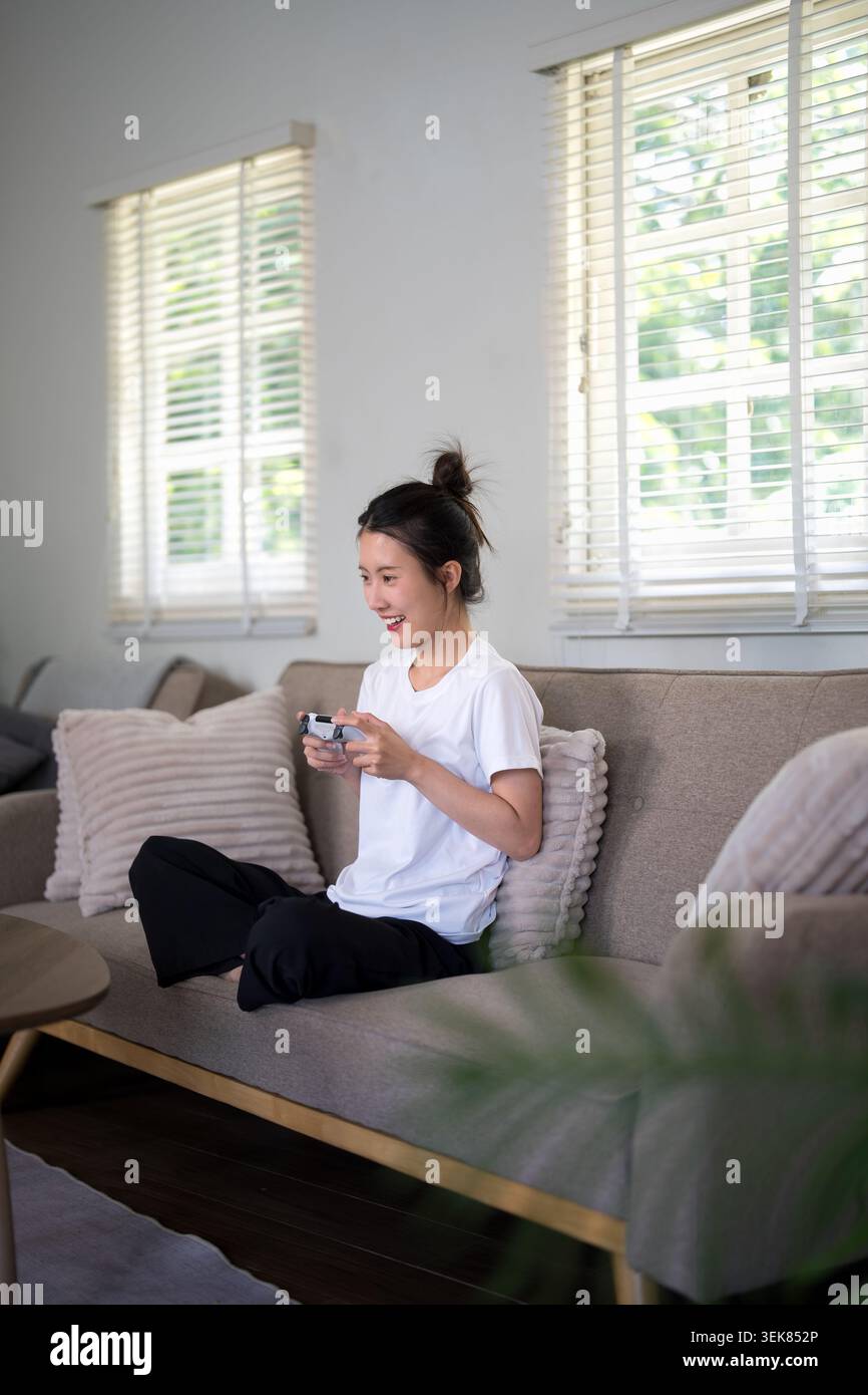 young Asian women sitting on sofa holding medicine pills bottle reading ...