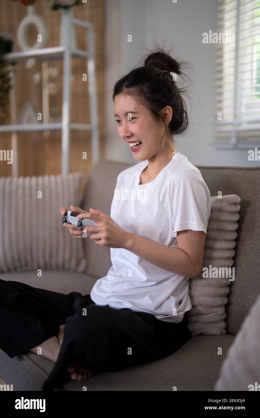 young Asian women playing video game using controller relaxing on ...