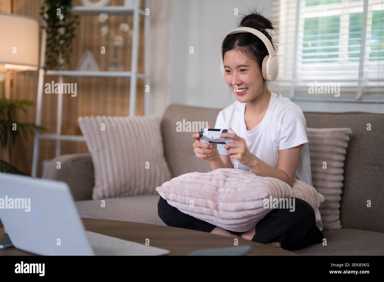 young Asian women playing video game with wireless controller and ...