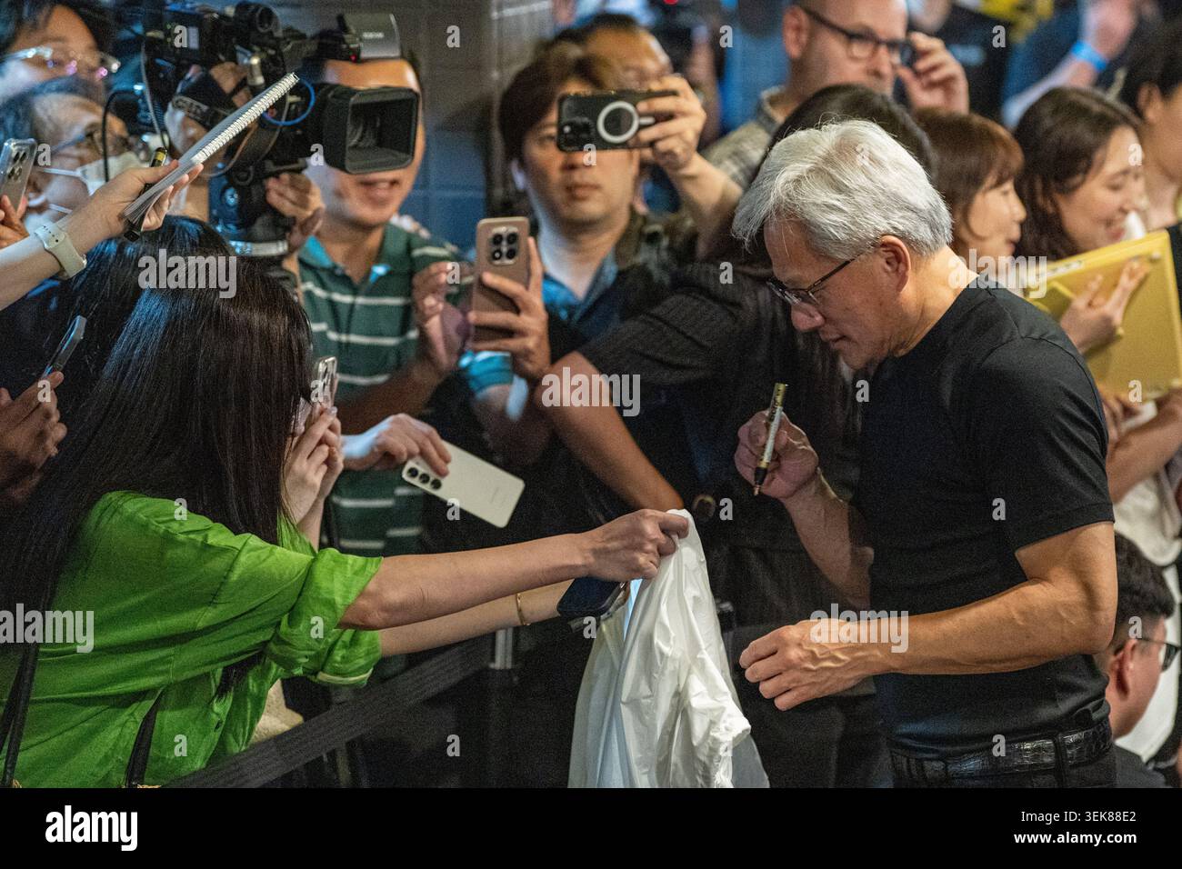 Jensen Huang, President and CEO of NVIDIA signing objects from fans ...