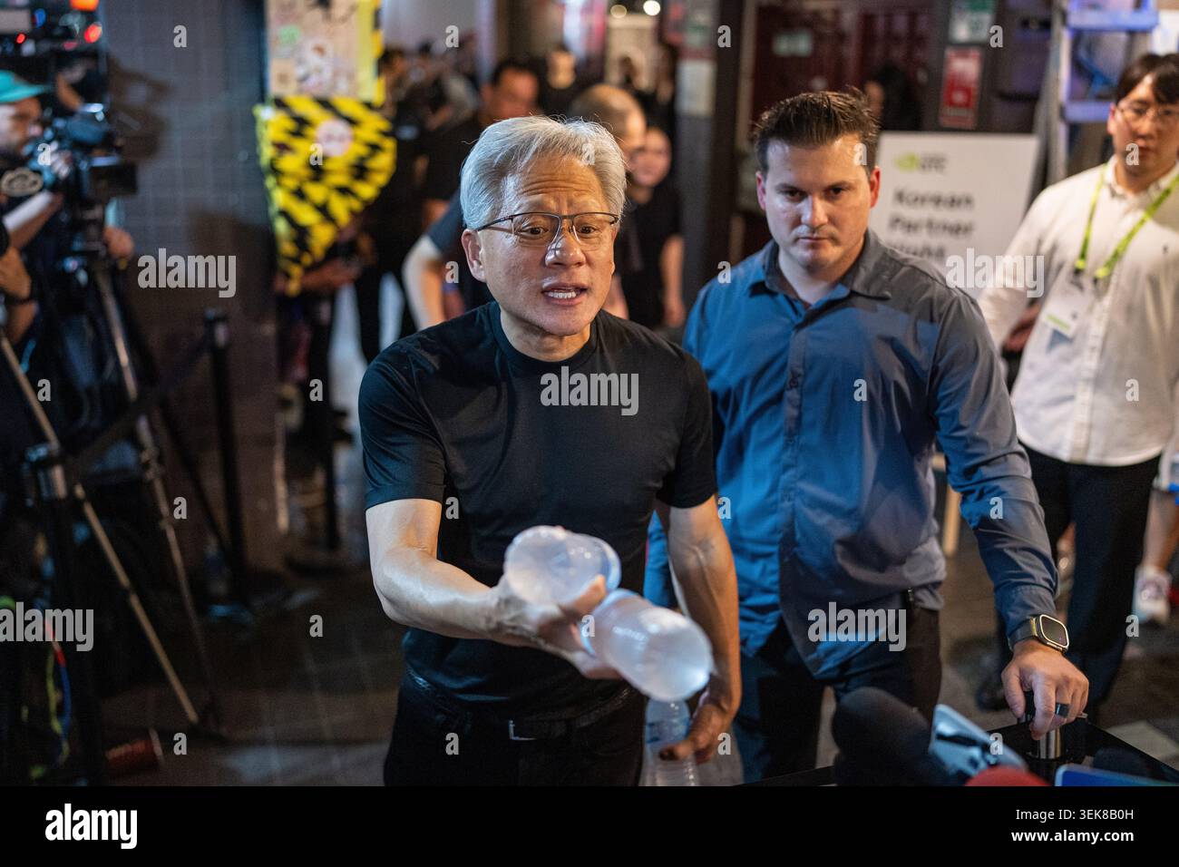 Jensen Huang, President and CEO of NVIDIA handing out water bottles to ...