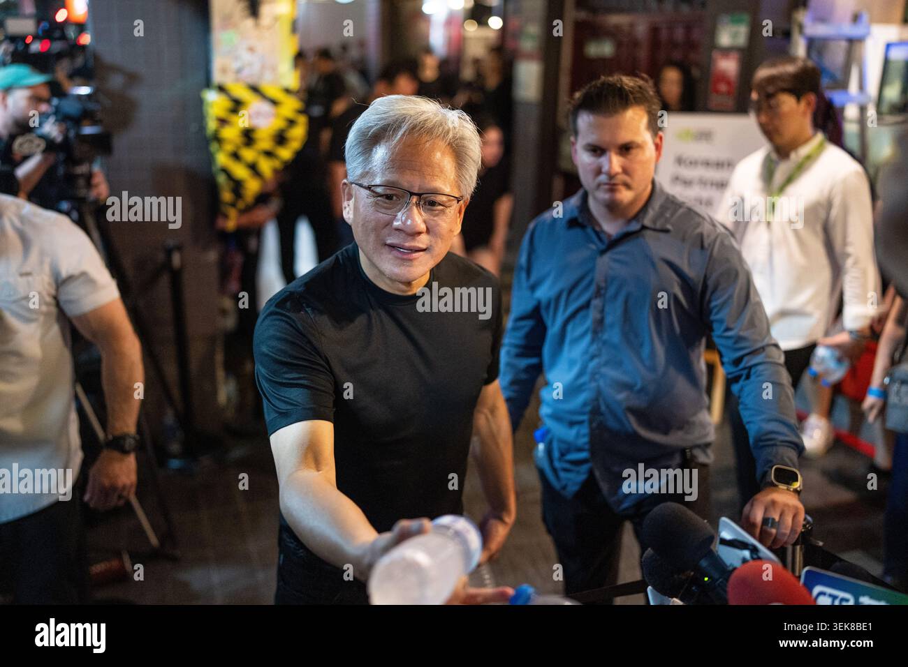 Jensen Huang, President and CEO of NVIDIA handing out water bottles to ...