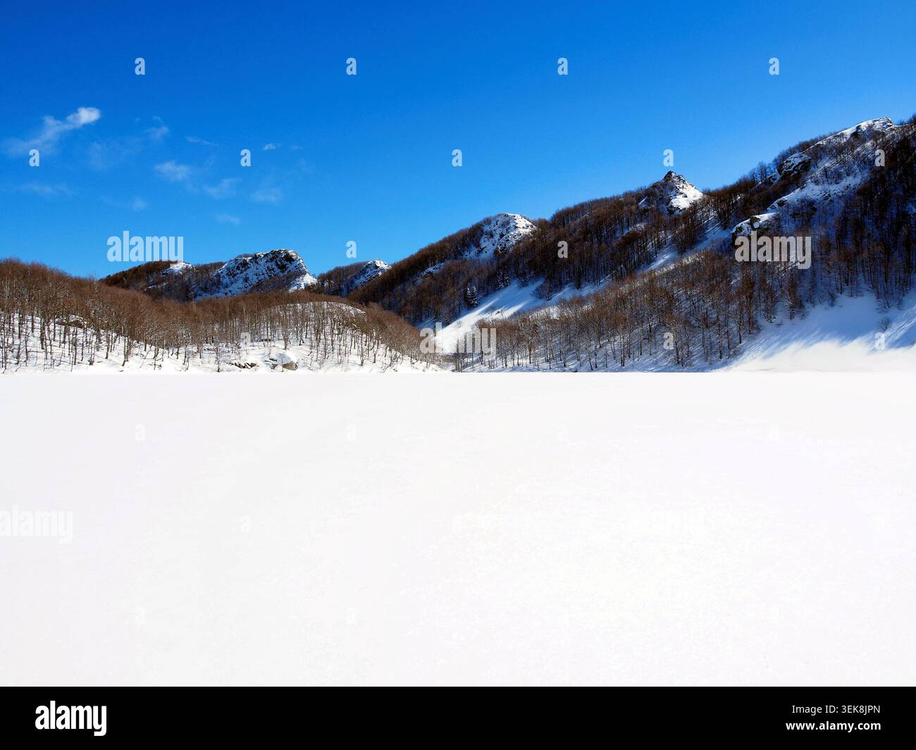 Frozen Lago Santo lake under a bright blue sky in spring. LAGO SANTO ...