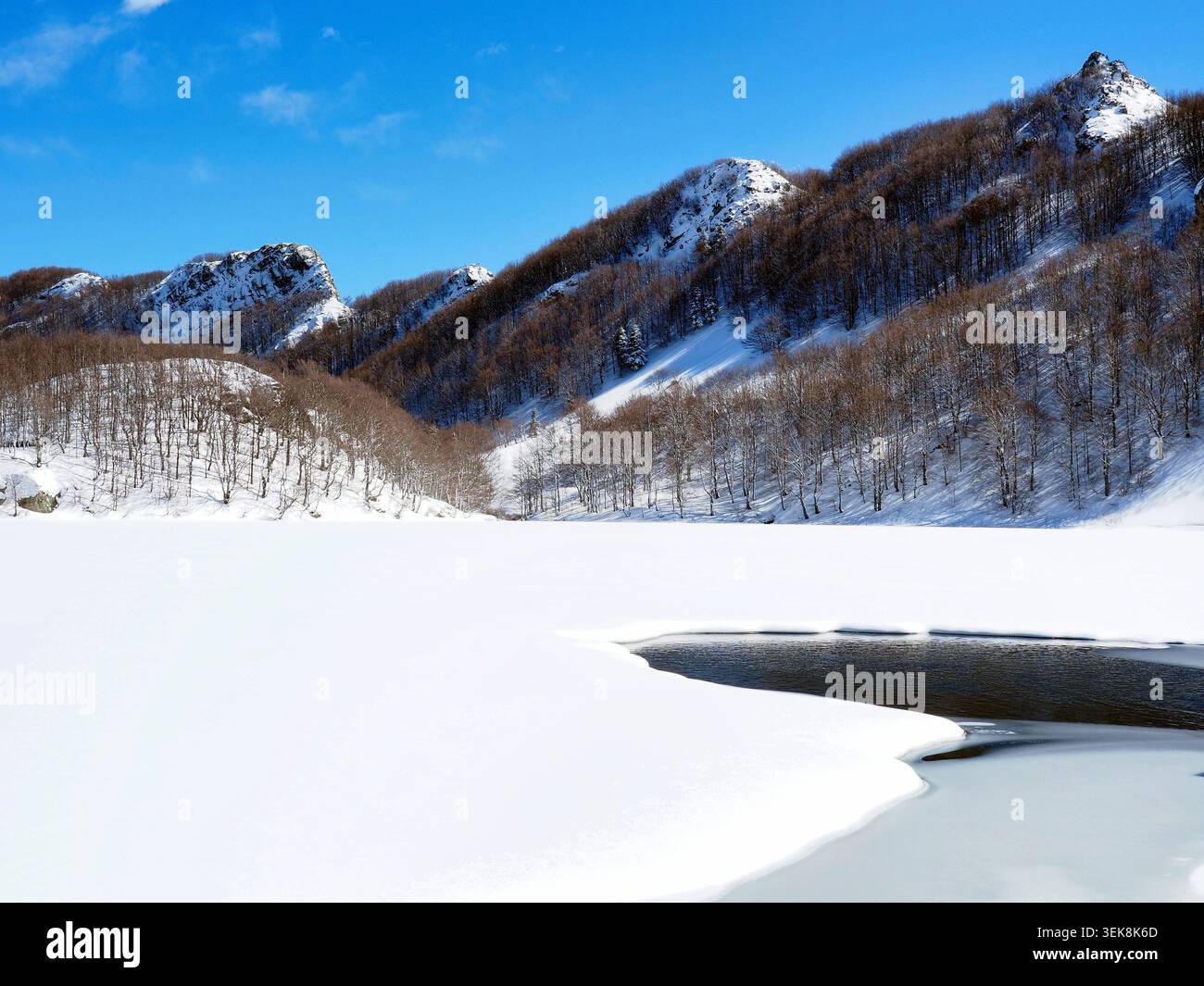 Frozen Lago Santo lake under a bright blue sky in spring. LAGO SANTO ...
