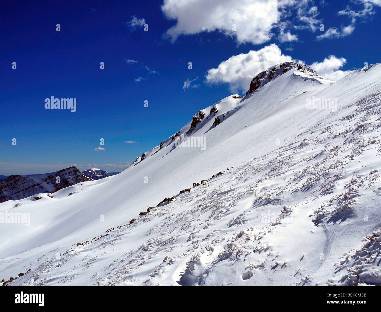 Steep snowy mountain ridge of Monte Aquila under a blue sky. MONTE ...