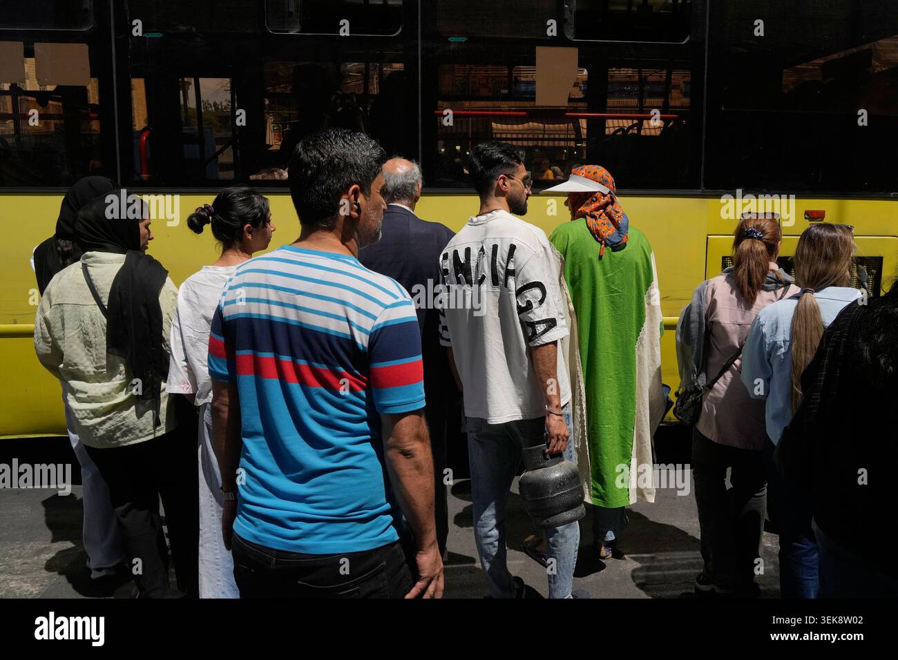 Pedestrians and a public bus cross an intersection around Tehran's ...