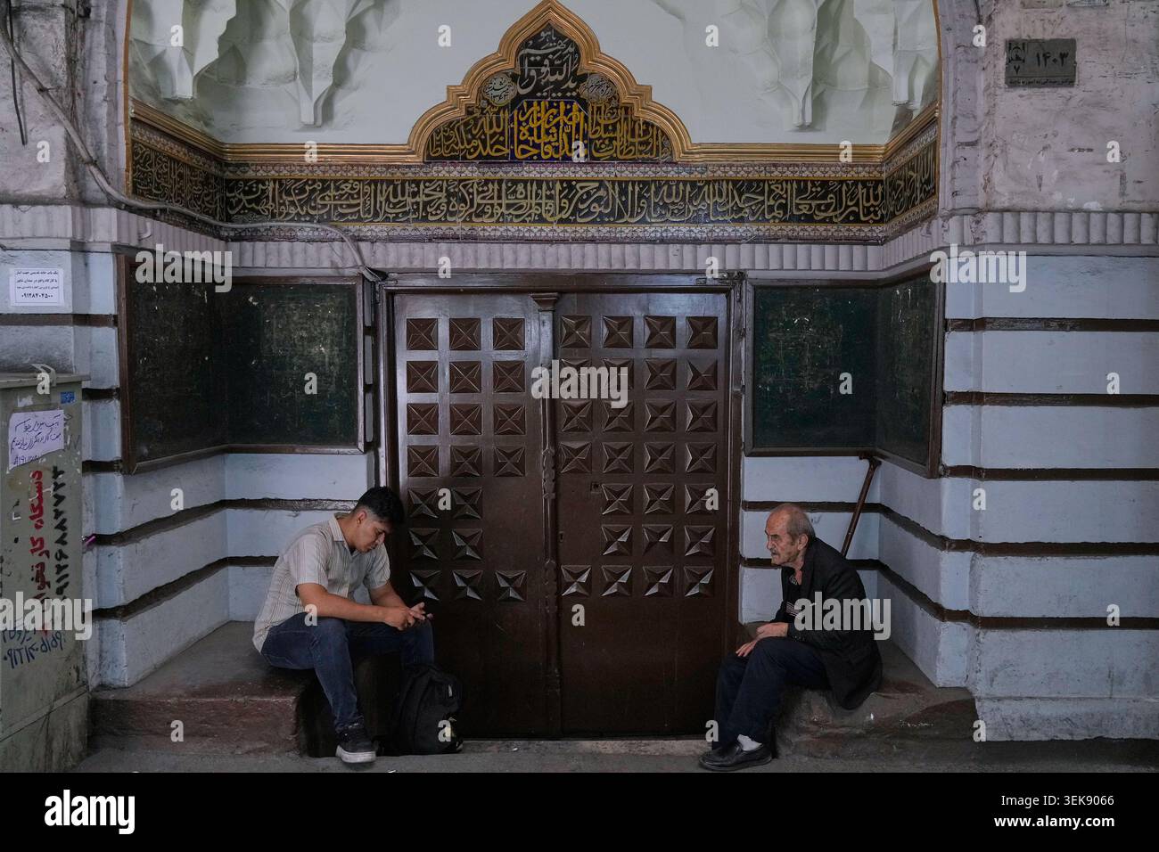 Men sit at the gate of a mosque at Tehran's historic Grand Bazaar, Iran ...
