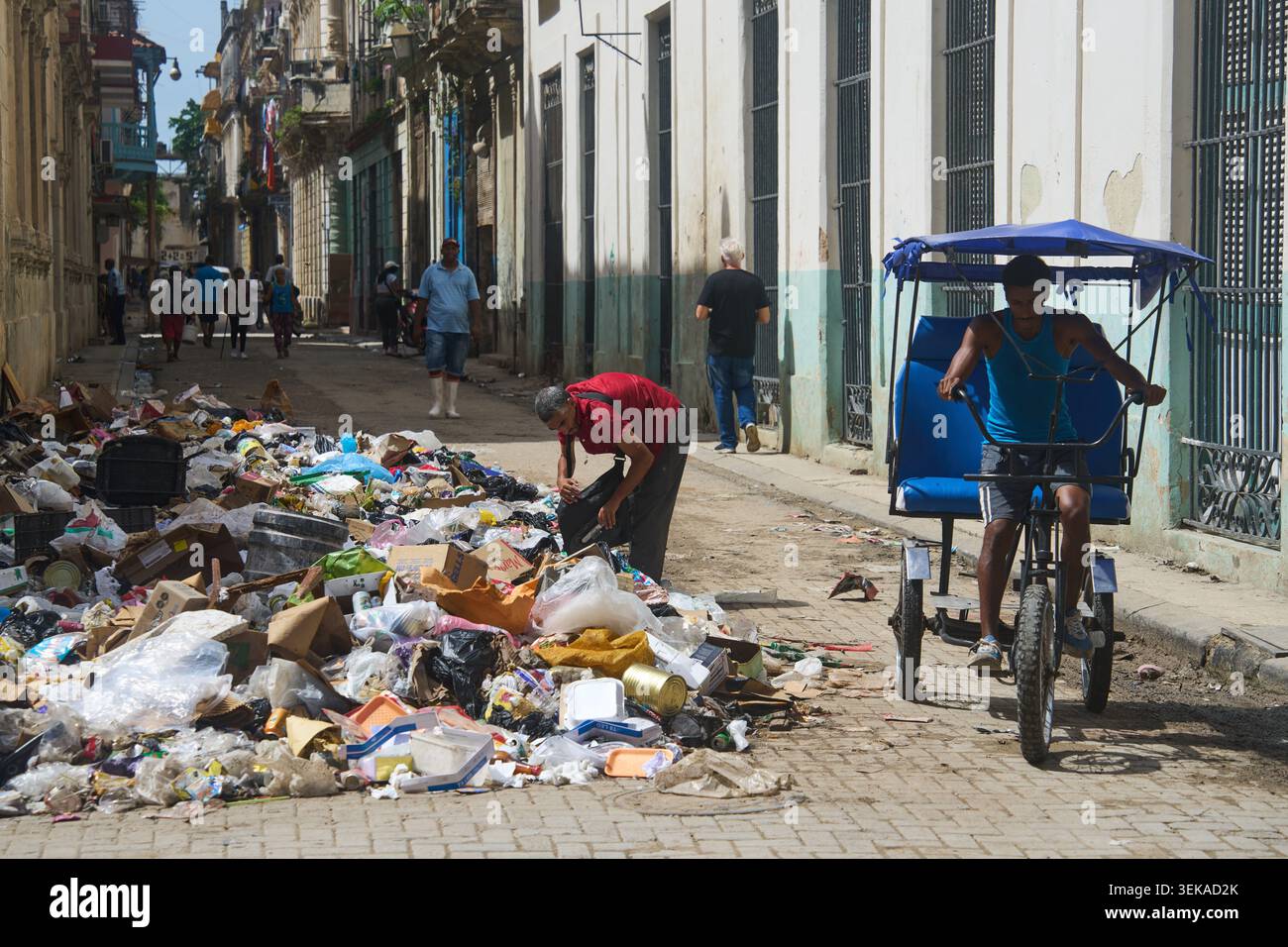 A man searches through a pile of trash for items to salvage in Havana ...