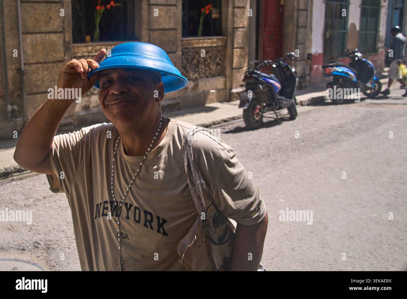 A man smiles at the camera while shading himself from the sun with a ...