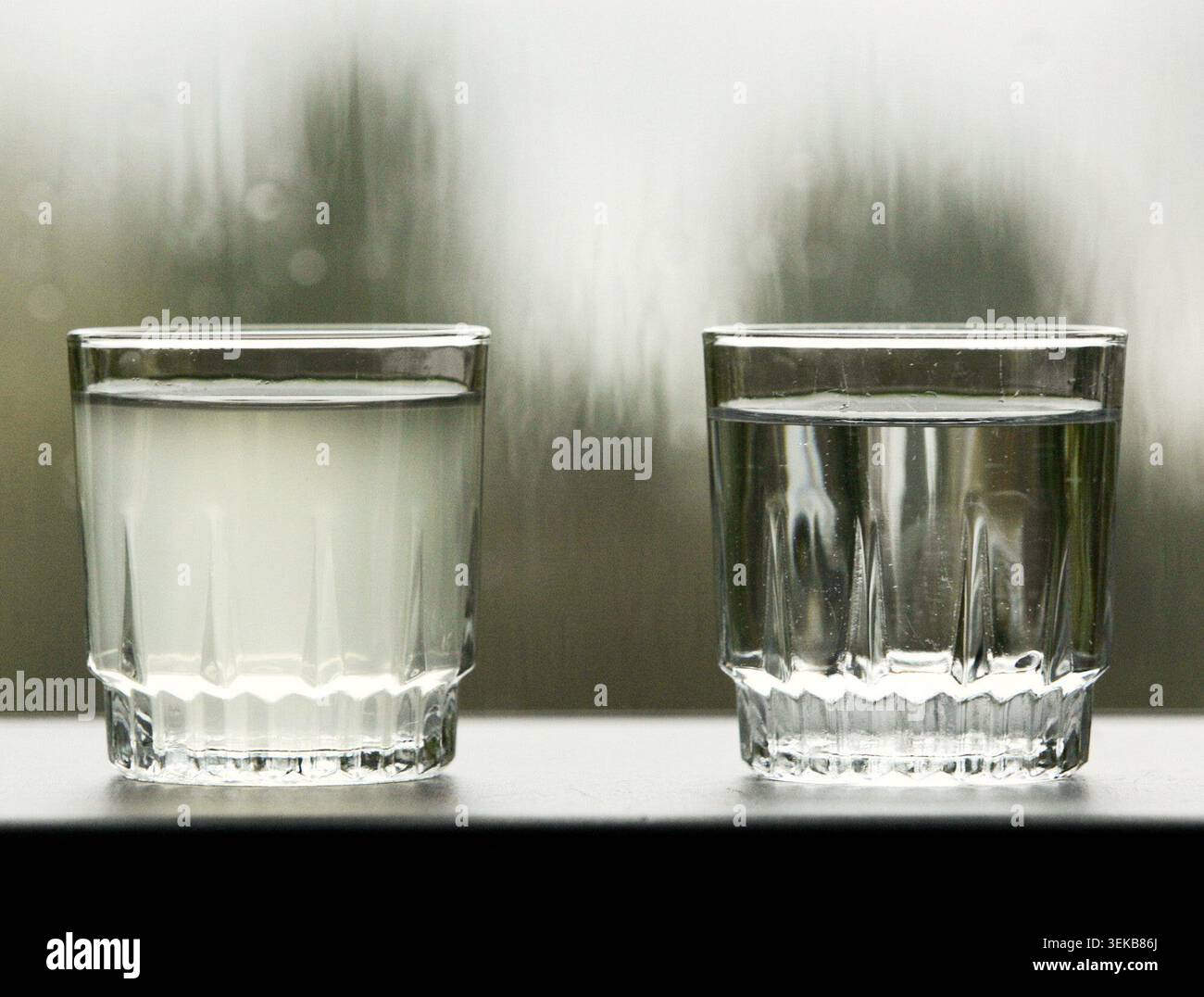A glass of filtered water right, looks clear next to a glass of turbid ...