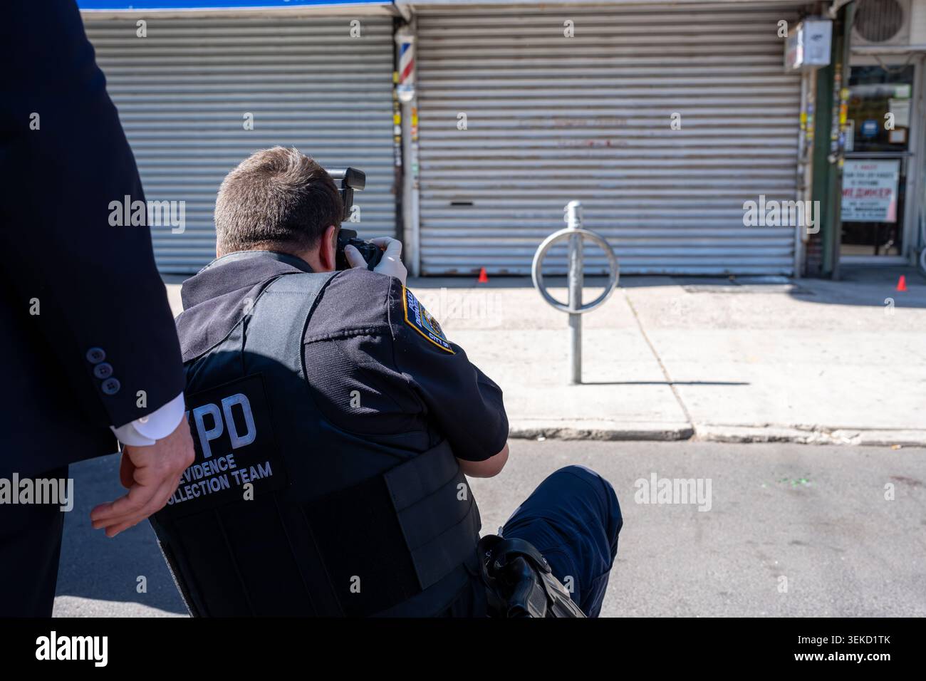 A police evidence collection team member photographs a crime scene on a ...