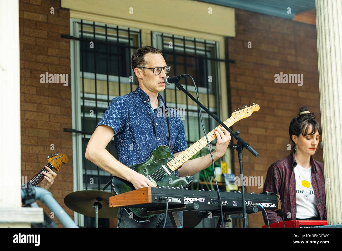 A vocalist with a guitar performs on a porch with his band at the West ...