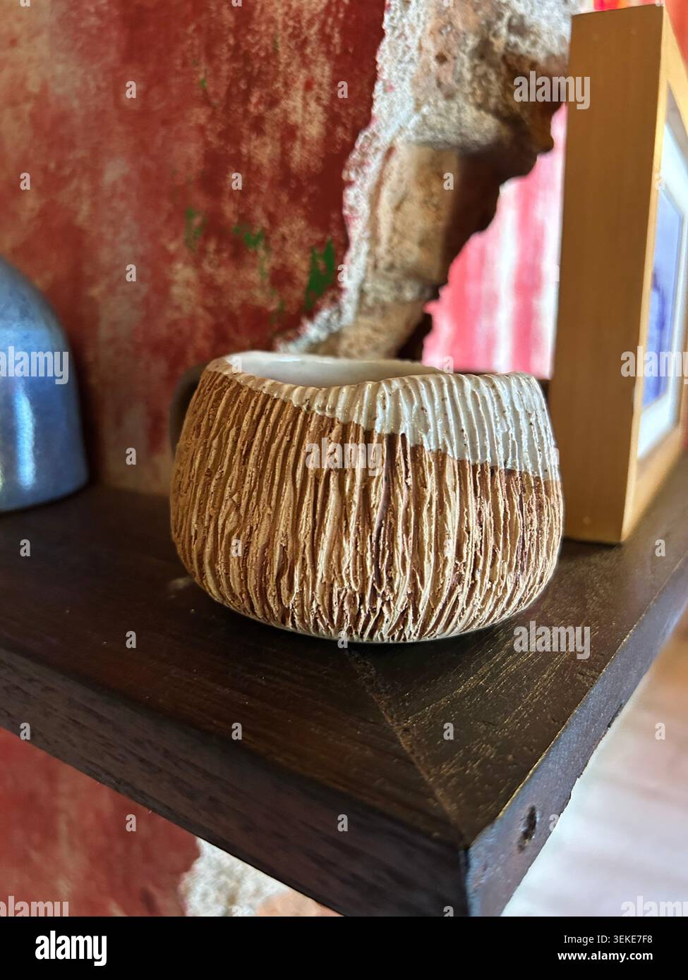 Handmade ceramic bowl with textured ribbed pattern on a rustic wooden ...