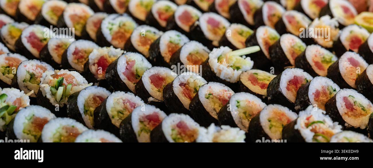 Neatly arranged rows of sushi rolls with colorful fillings and toppings ...