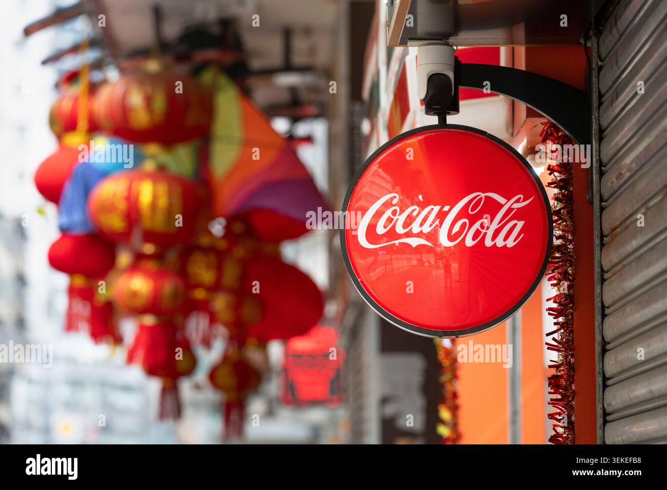 Close-up of a Coca-Cola logo seen displayed amidst festive red lanterns ...