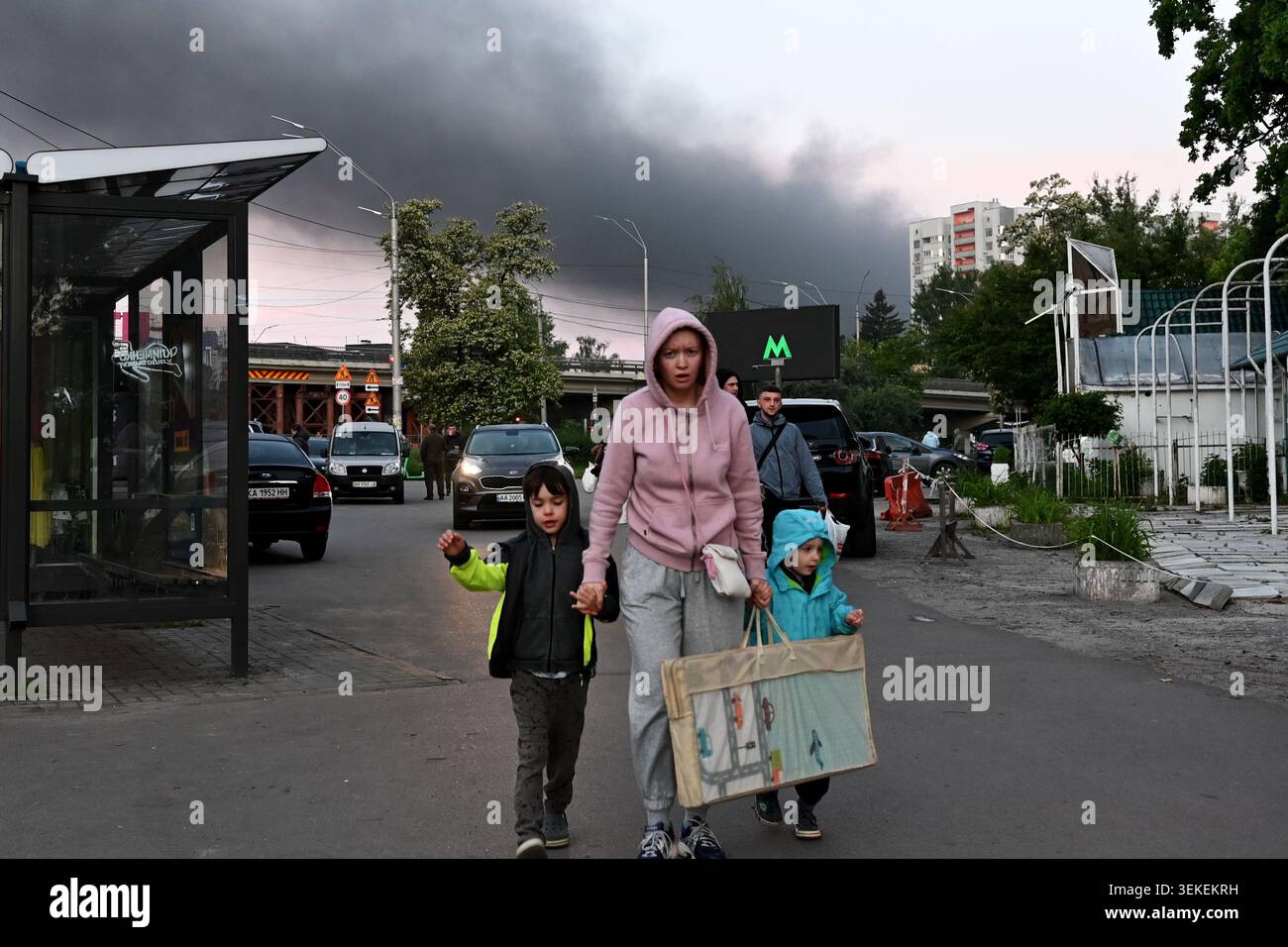 People return from shelter against a backdrop of black smoke in the sky ...