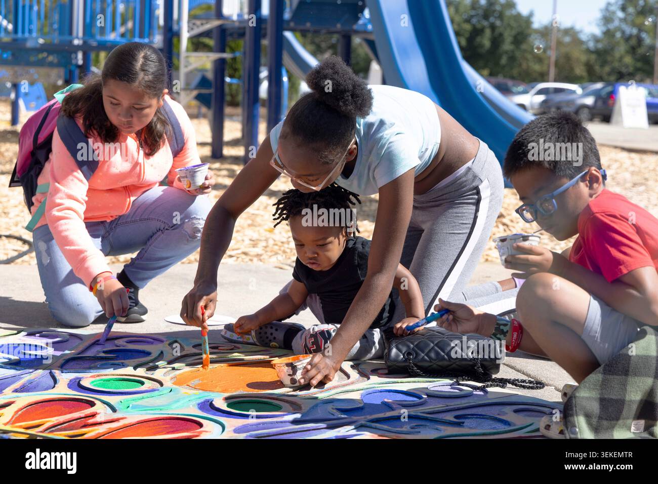 FILE - Children paint a display on the ground at a back to school ...