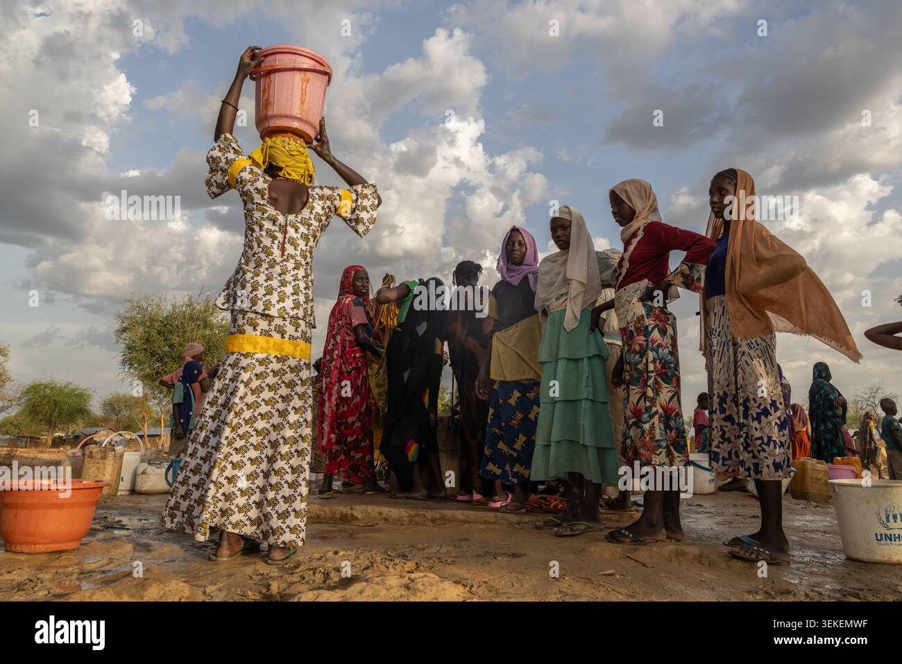 Women and children fetch water at dusk in the Korsi Refugee Camp in ...