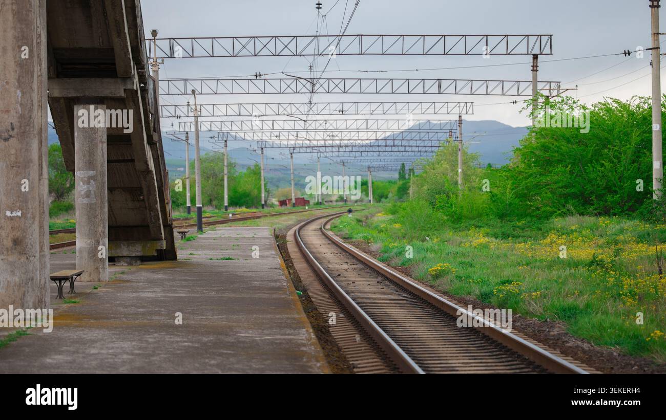 Perspective view of empty train tracks and concrete platform under ...
